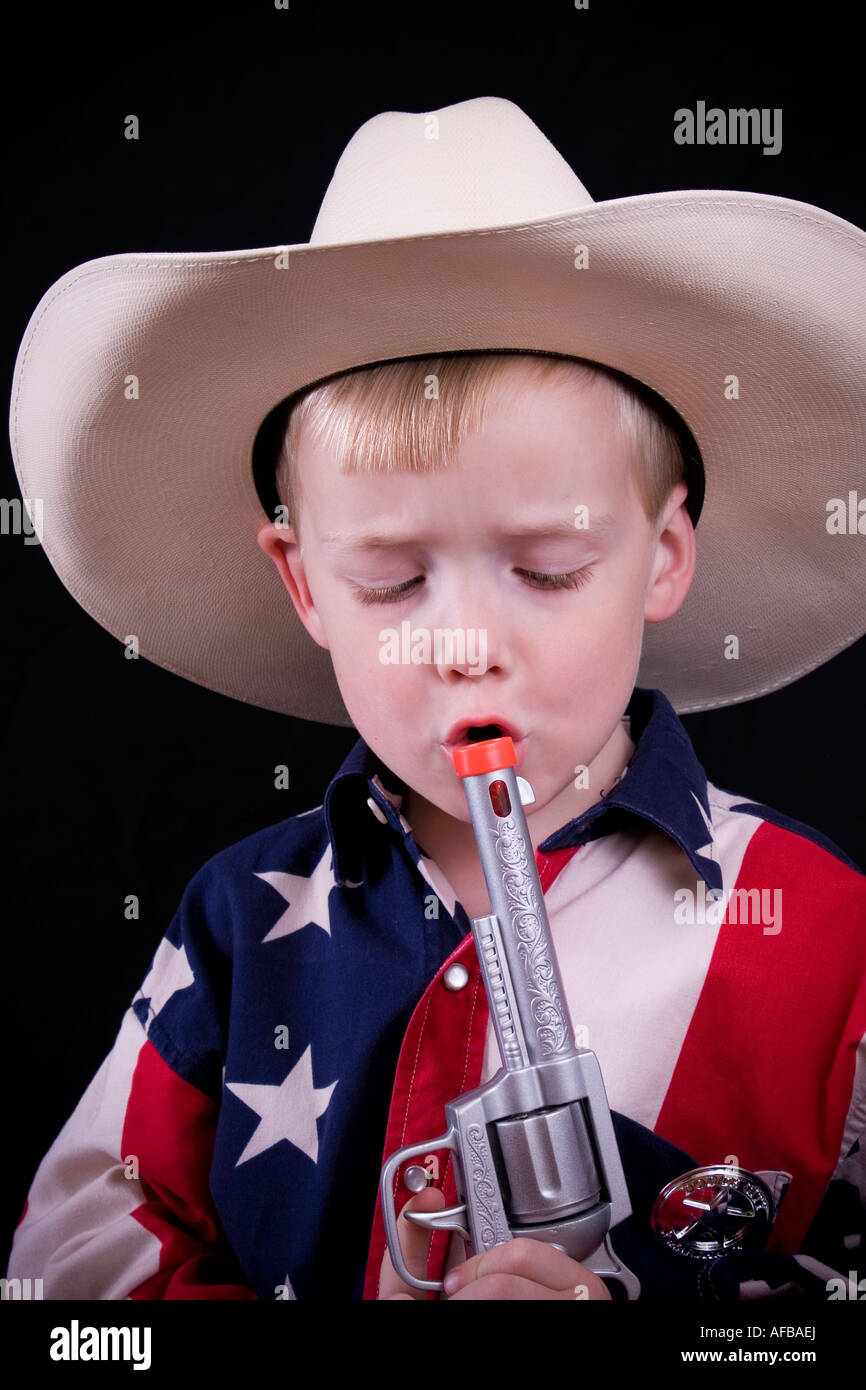 Cute little five year old cowboy blowing the smoke off his gun Stock ...