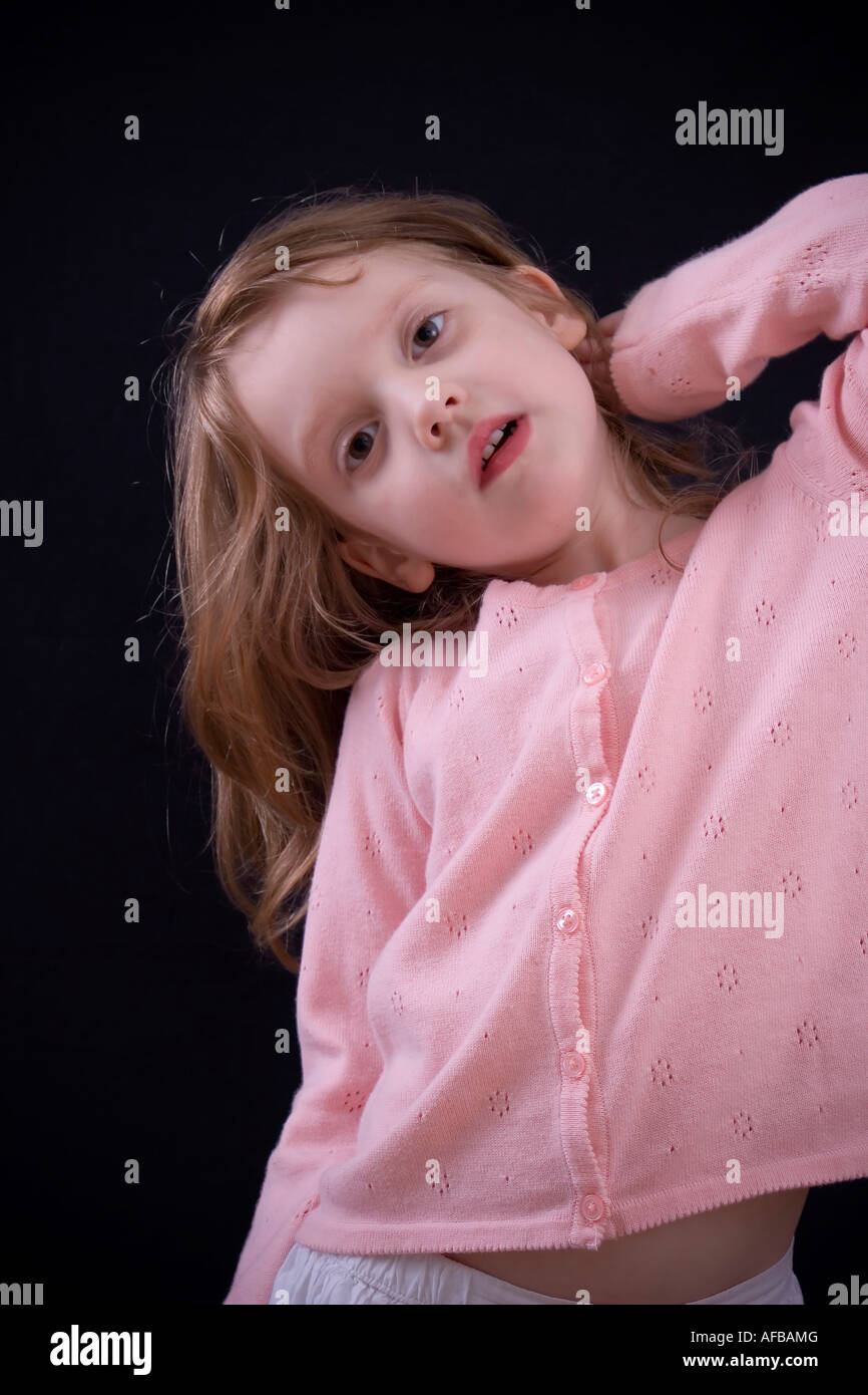 Beautiful little four year old girl on a black background Stock Photo - Alamy