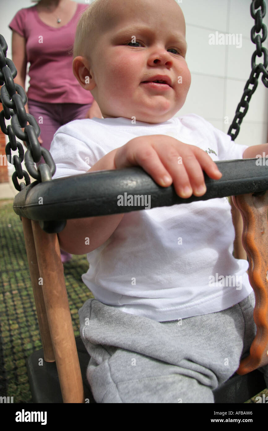 mother pushing baby on swing Stock Photo - Alamy