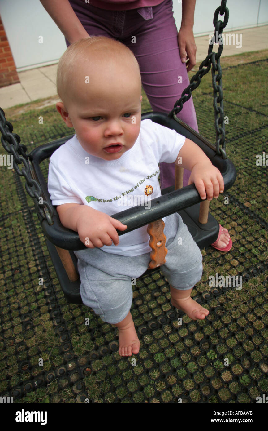 mother pushing baby on swing Stock Photo - Alamy