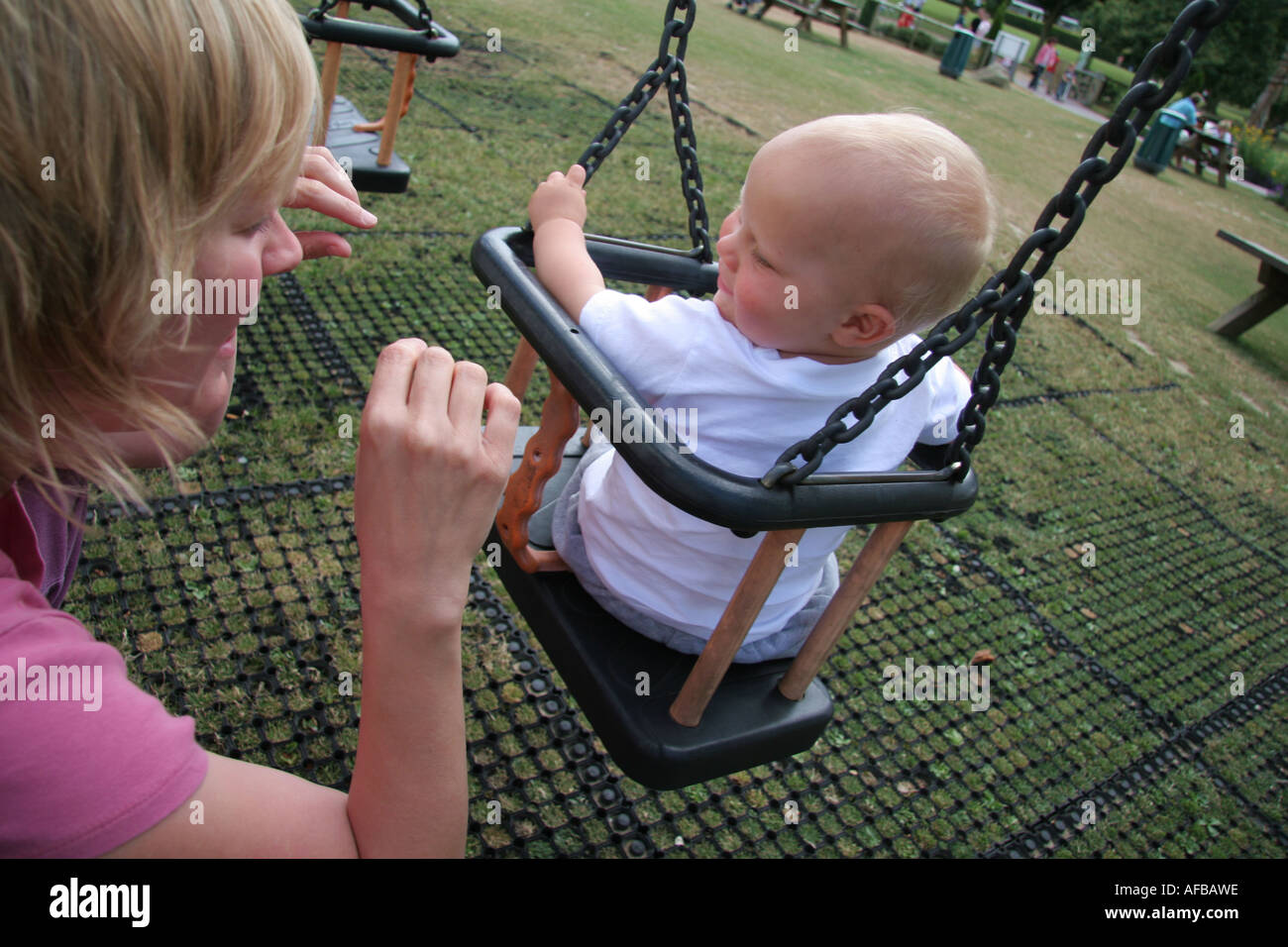mother pushing baby on swing Stock Photo - Alamy