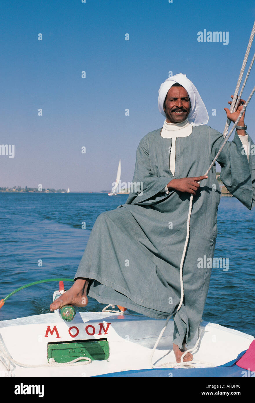 Egyptian sailor at the helm of his FELUCCA on the River Nile at Luxor ...