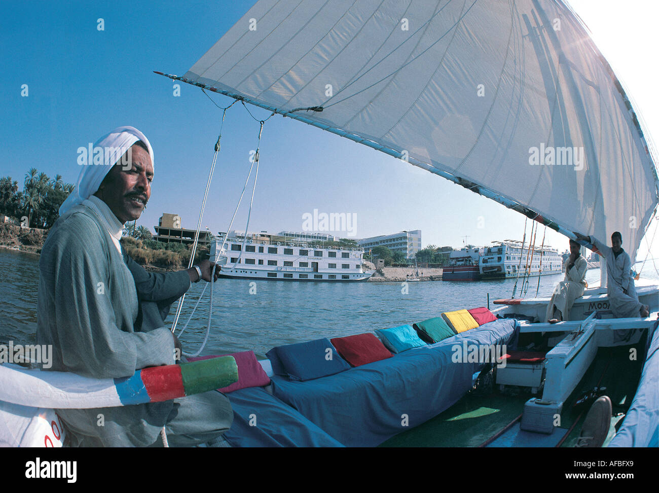 Egyptian sailor at the helm of his FELUCCA on the River Nile at Luxor ...