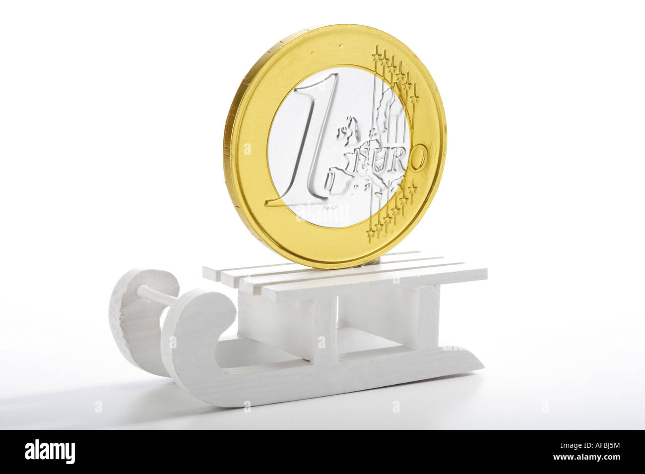 Euro coin on toy sledge Stock Photo - Alamy