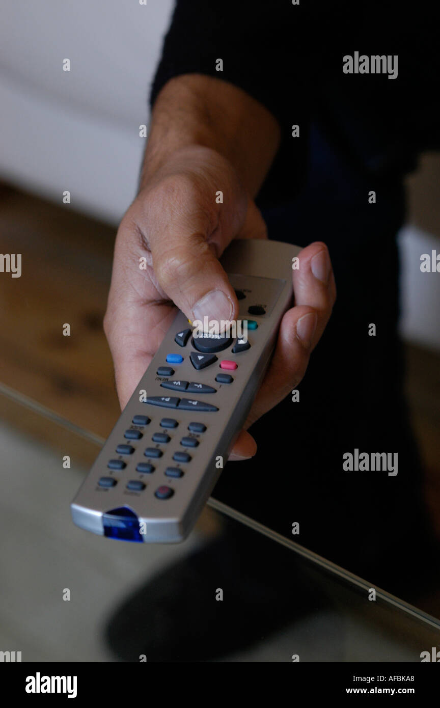 remote control for tv or dvd with a black hand Stock Photo - Alamy