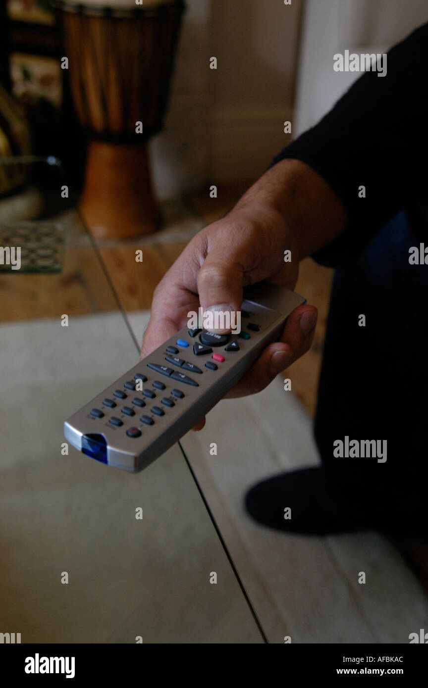 remote control for tv or dvd with a black hand Stock Photo - Alamy