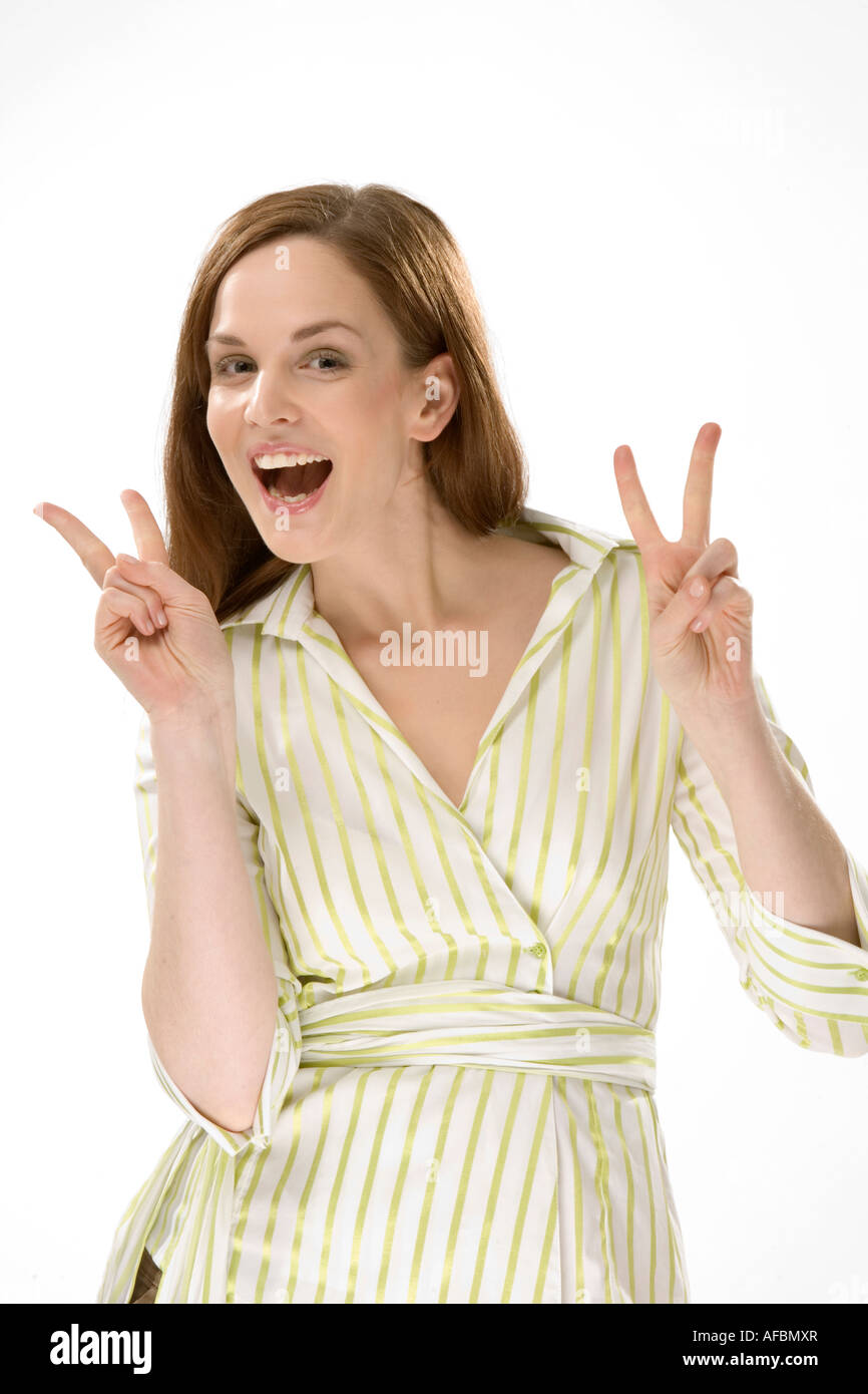 Young woman giving peace signs, smiling, portrait Stock Photo - Alamy