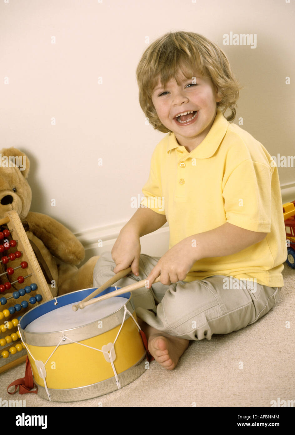 Young boy beating a toy drum Stock Photo - Alamy