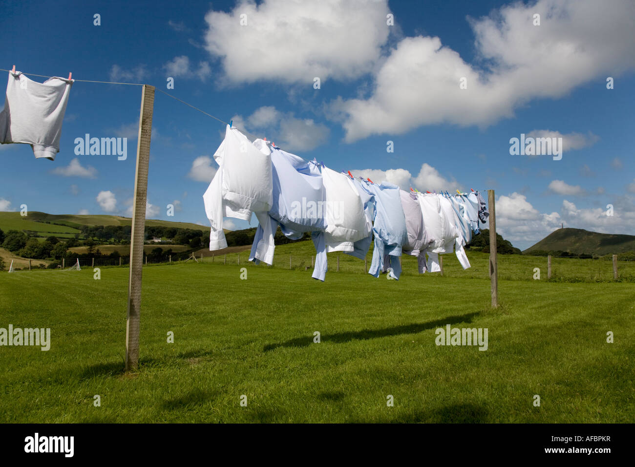 Washing line at a farm, with green fields and blue sky Stock Photo - Alamy