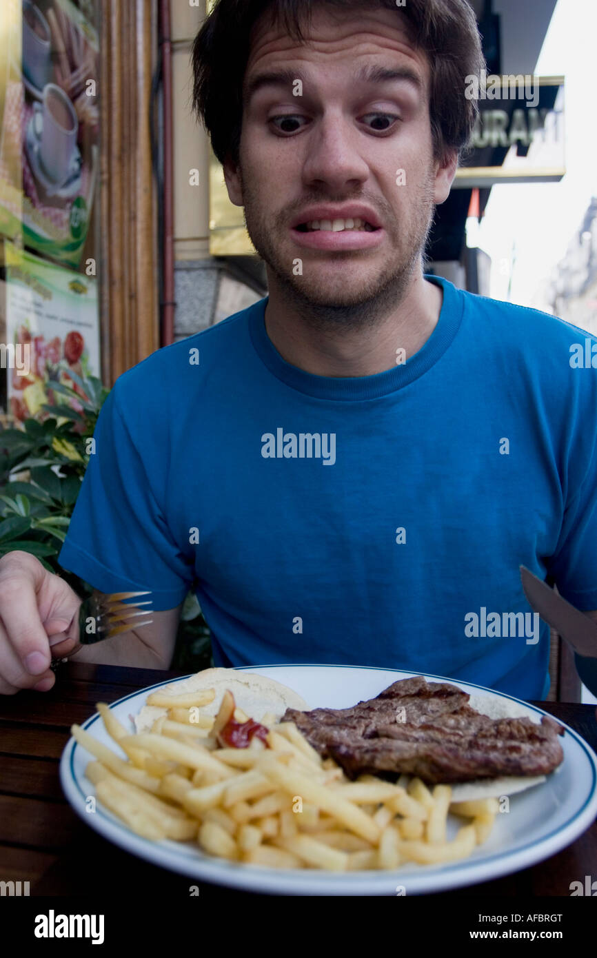 Man Looking at his Plate of Food with Expression of Disgust Stock Photo ...