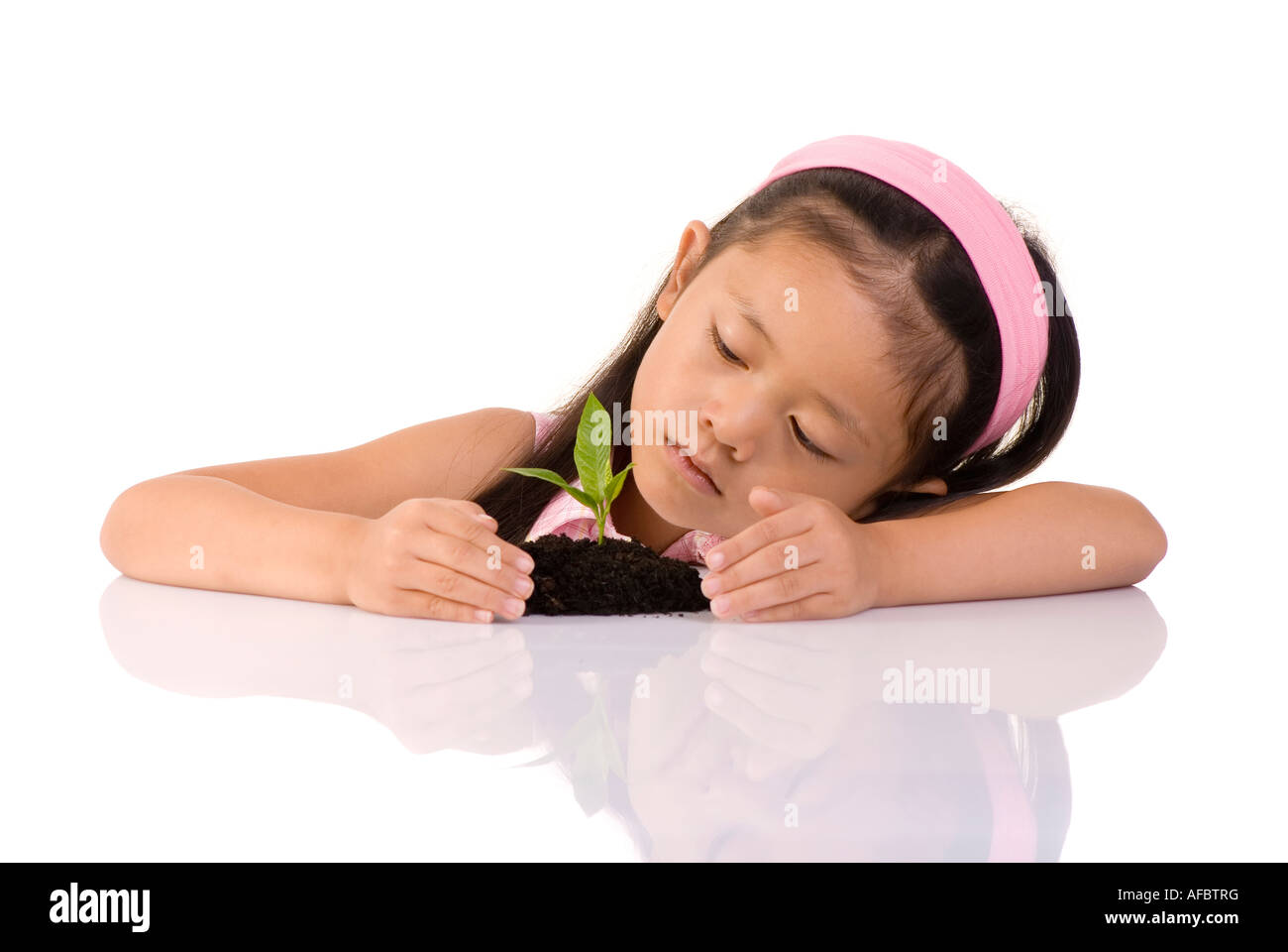 A young child protects a small seedling that has just sprouted Stock ...