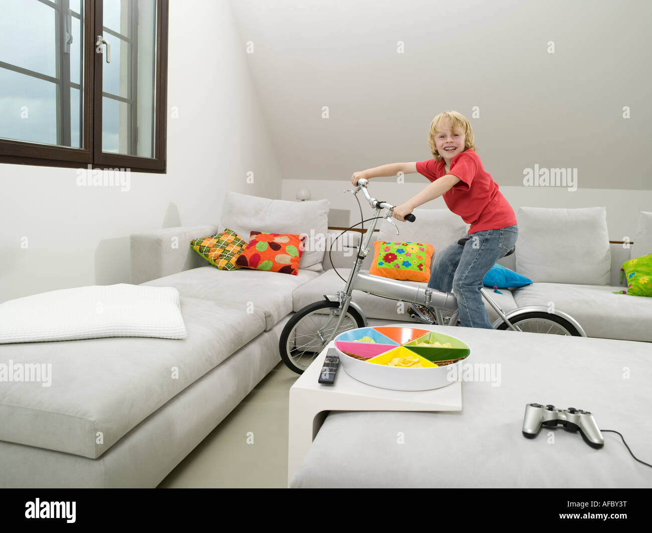 Boy cycling in living room Stock Photo - Alamy
