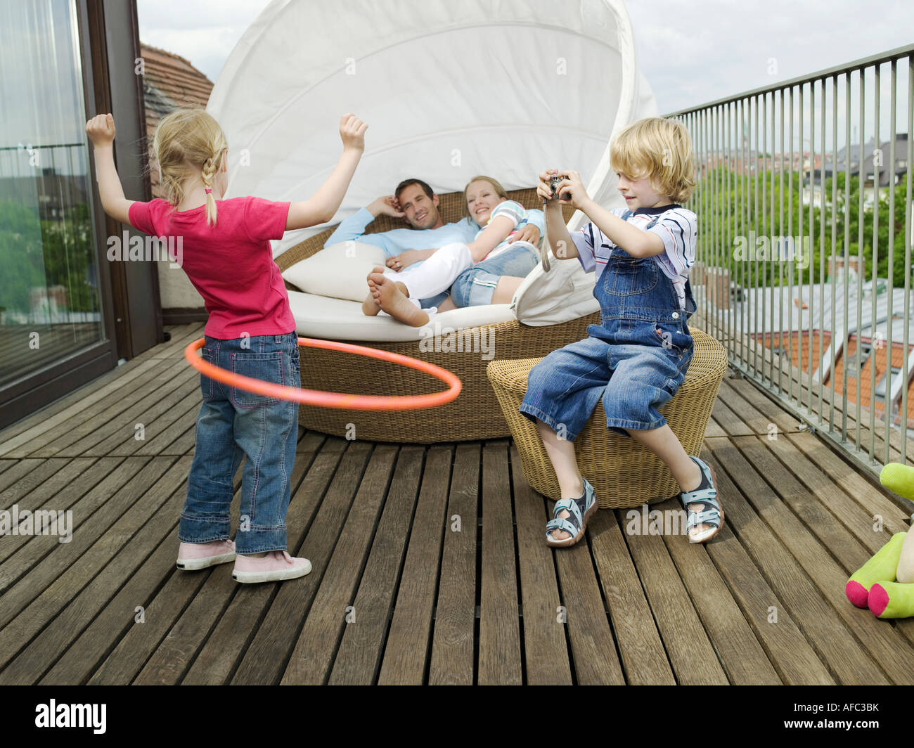 Family on balcony, children playing Stock Photo - Alamy