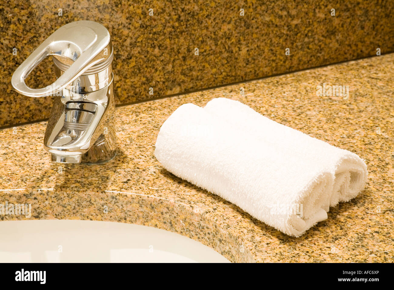Closeup of a luxurious bathroom sink with fluffy face towels on a ...