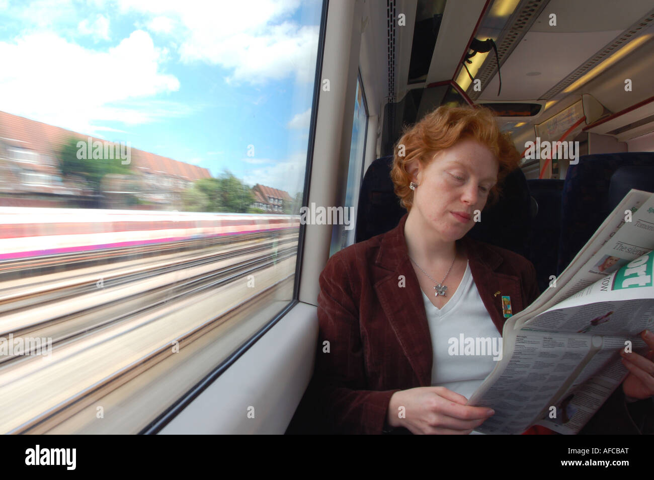 Commuter on train travelling to London Stock Photo - Alamy