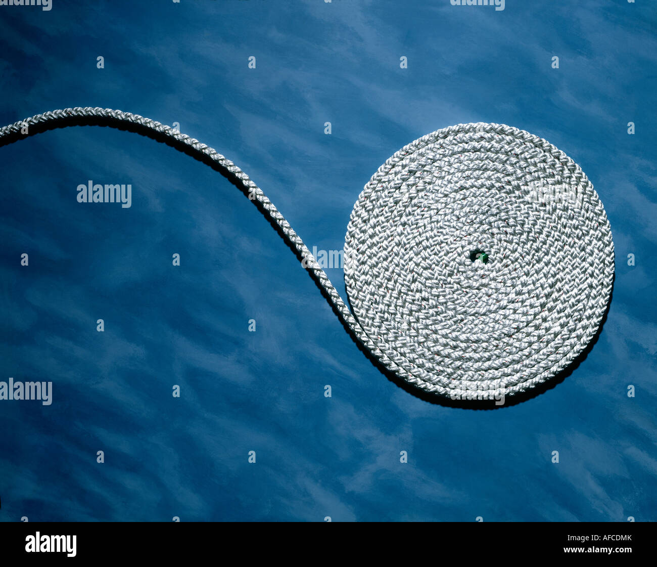 Coiled sailing rope on blue mottled background Stock Photo - Alamy