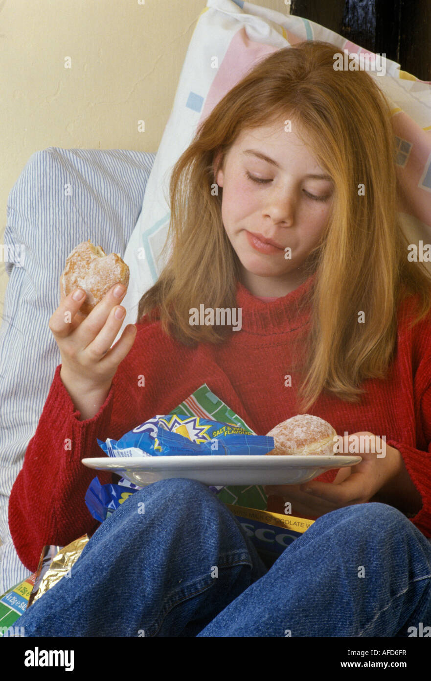 girl sitting on her bed binge eating Stock Photo - Alamy