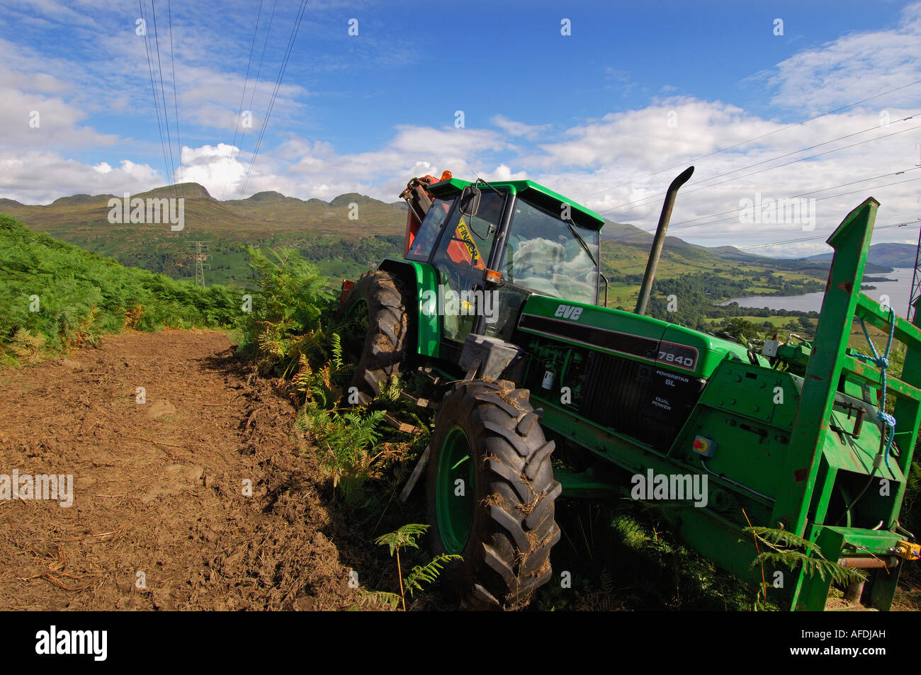 Large powerful tractor parked beneath high voltage power lines in a ...