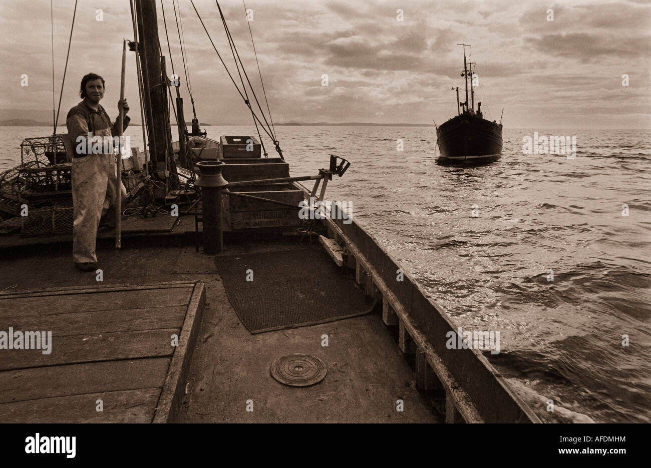 Sepia tinted monochrome shot of fishing boats meet out at sea off ...