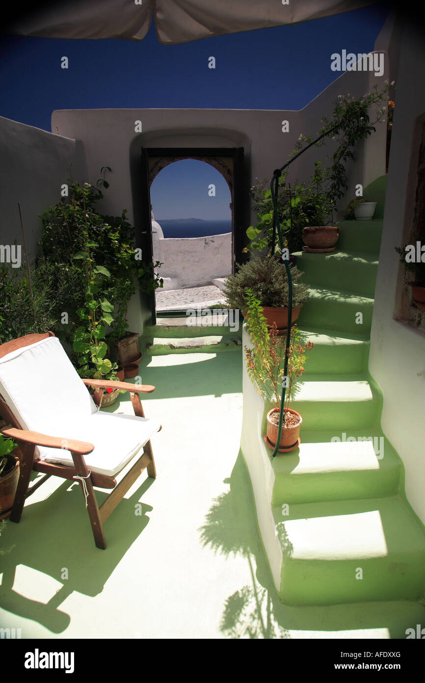 authentic greek courtyard with arched doorway, chair and staircase ...
