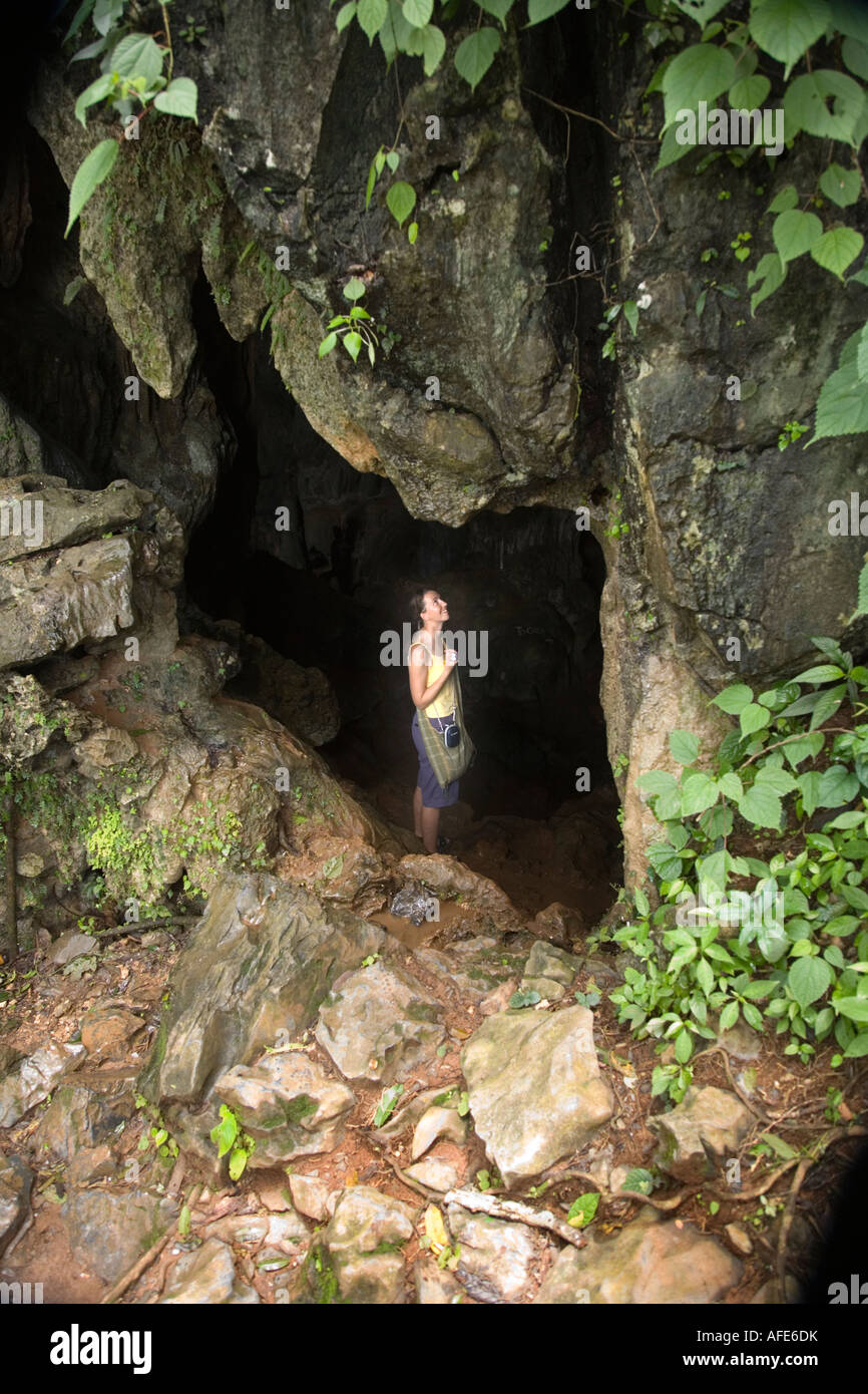 Female tourist in entrance to the Tham Phu Kham (Poukham) cave mouth ...