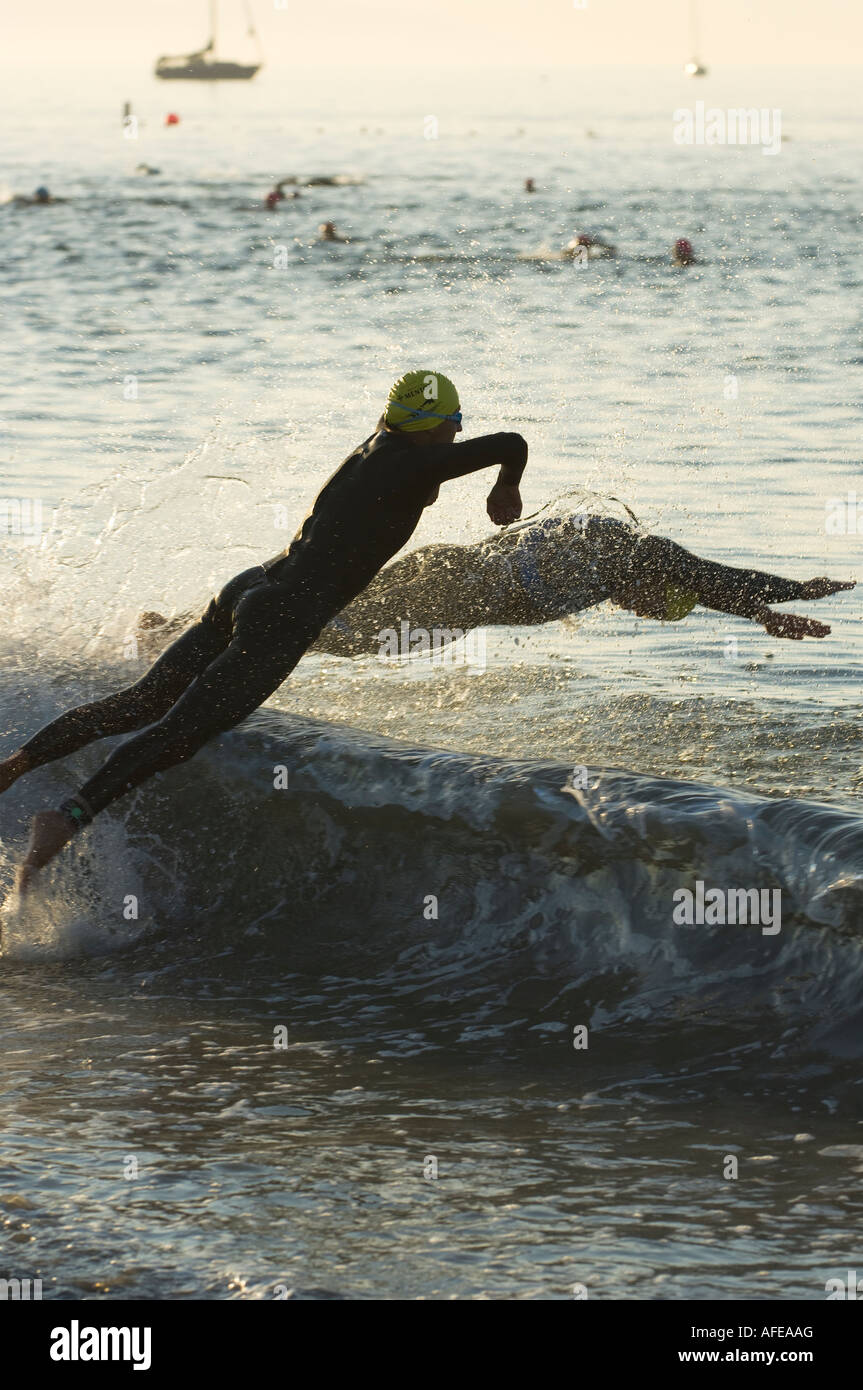 Swimmers dive over wave into cold Pacific ocean for swimming section of ...