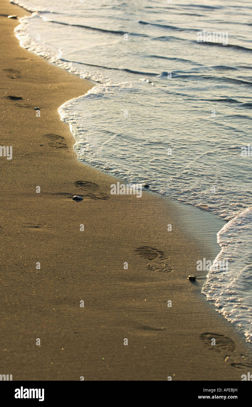 footprints in sand next to ocean Stock Photo - Alamy