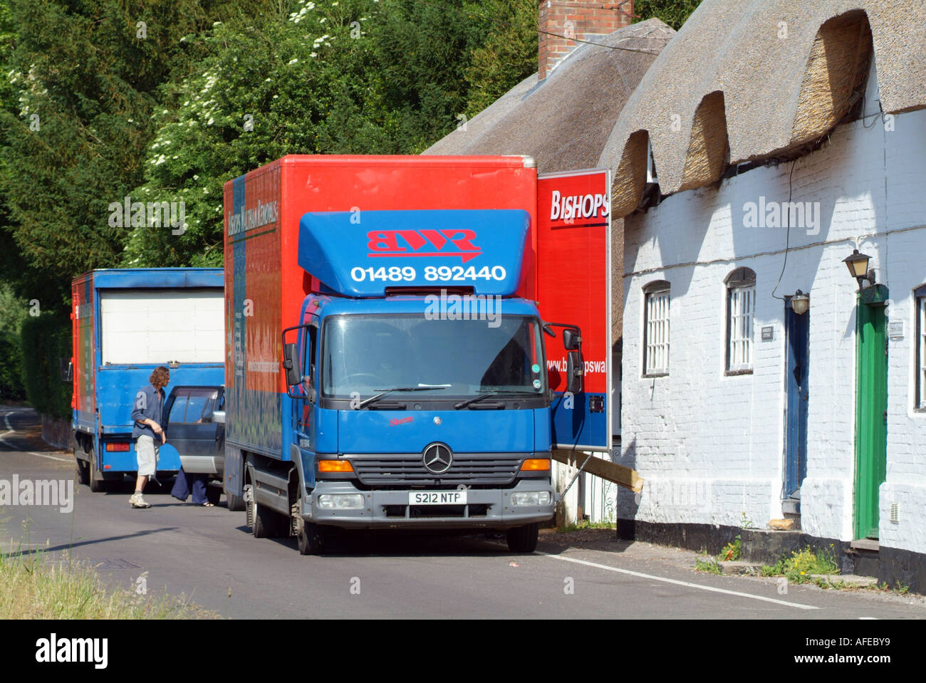 Moving home. Removal lorries outside thatched cottages Hampshire ...