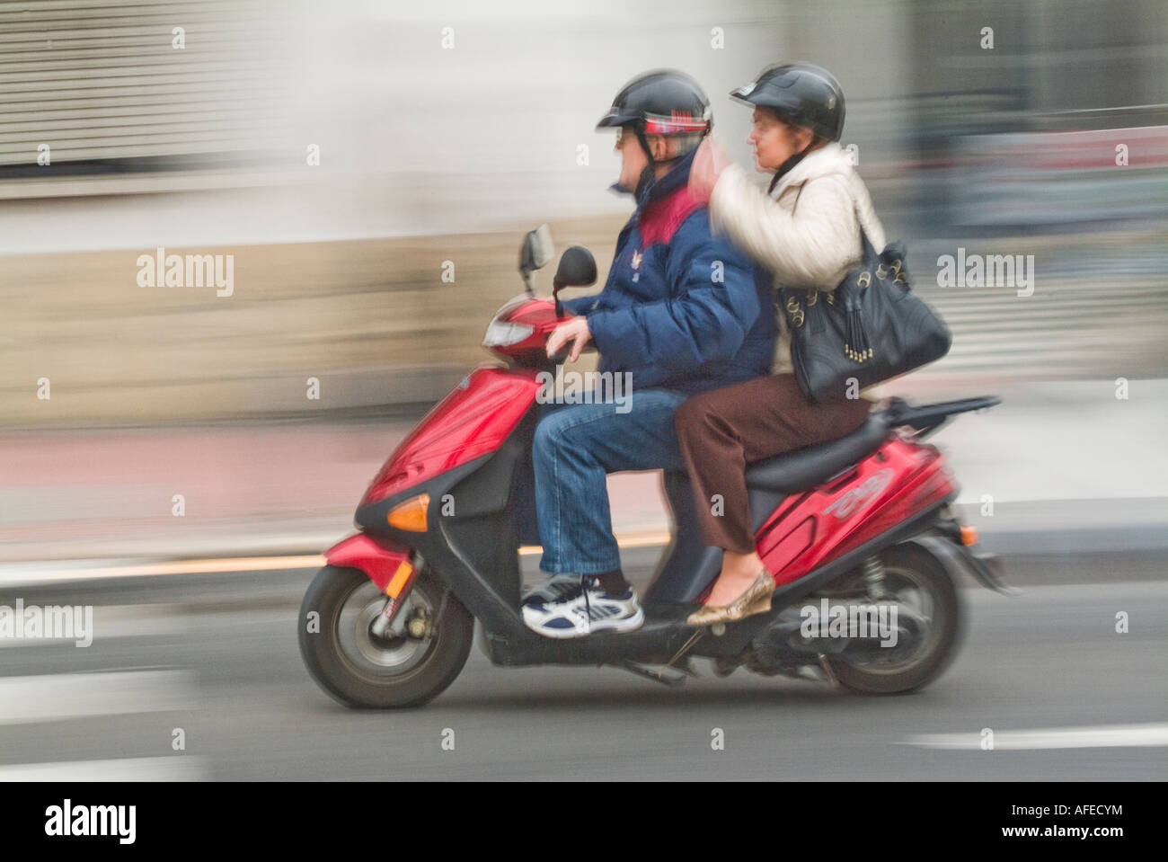 Mopeds with riders on city street in Nerja Spain Stock Photo - Alamy