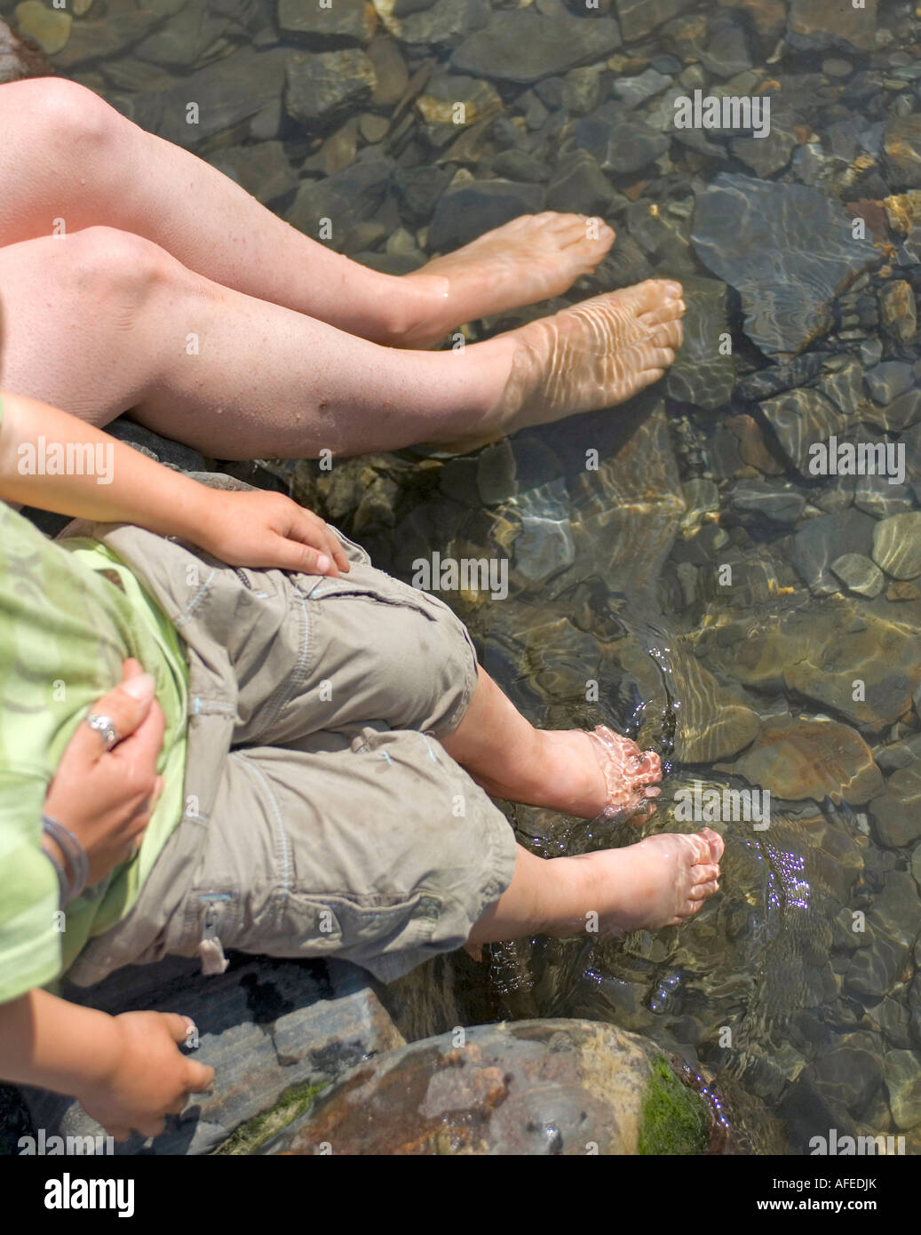 Mother and Son dipping feet into stream Stock Photo - Alamy