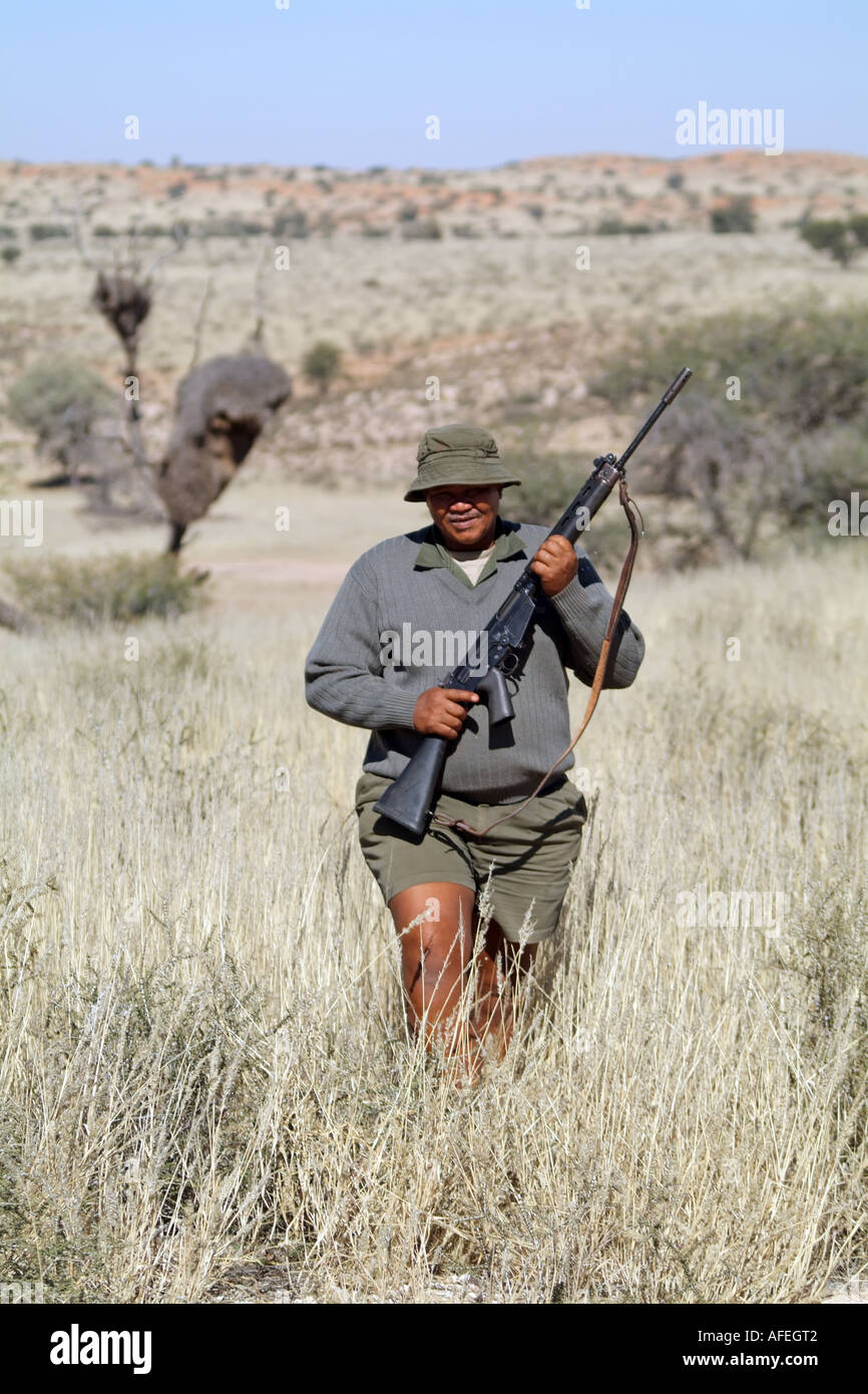 Ranger. Game warden holding a rifle walking in the grasslands savannah ...
