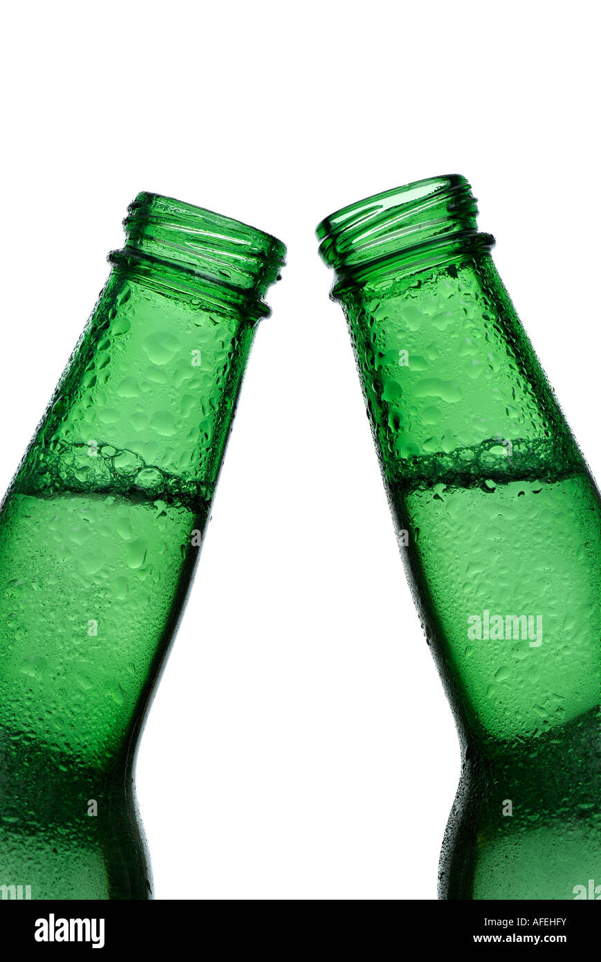 Cold Beer Bottles Tilted Towards Each Other in a Toast White Background ... Cold Beer Bottles Tilted Towards Each Other in a Toast White Background ...