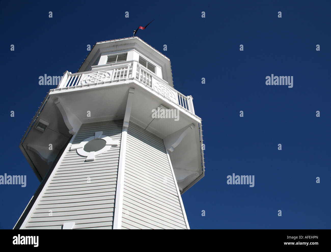 White lighthouse tower seen from below against a blue sky at Orlando ...
