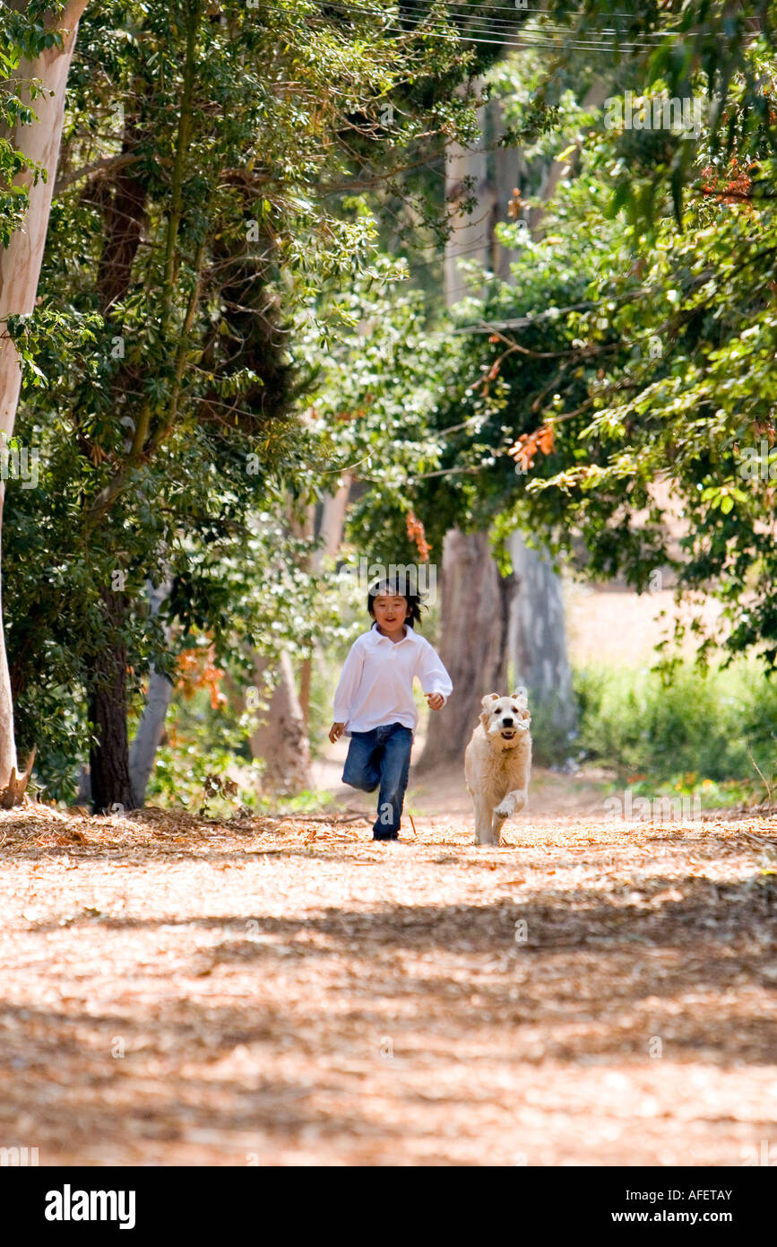 Boy Running with Dog Stock Photo - Alamy
