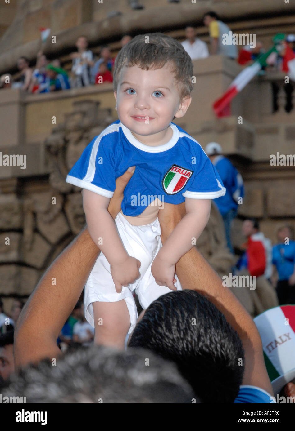 Italian fan holds his young child in the air while celebrating Italys ...