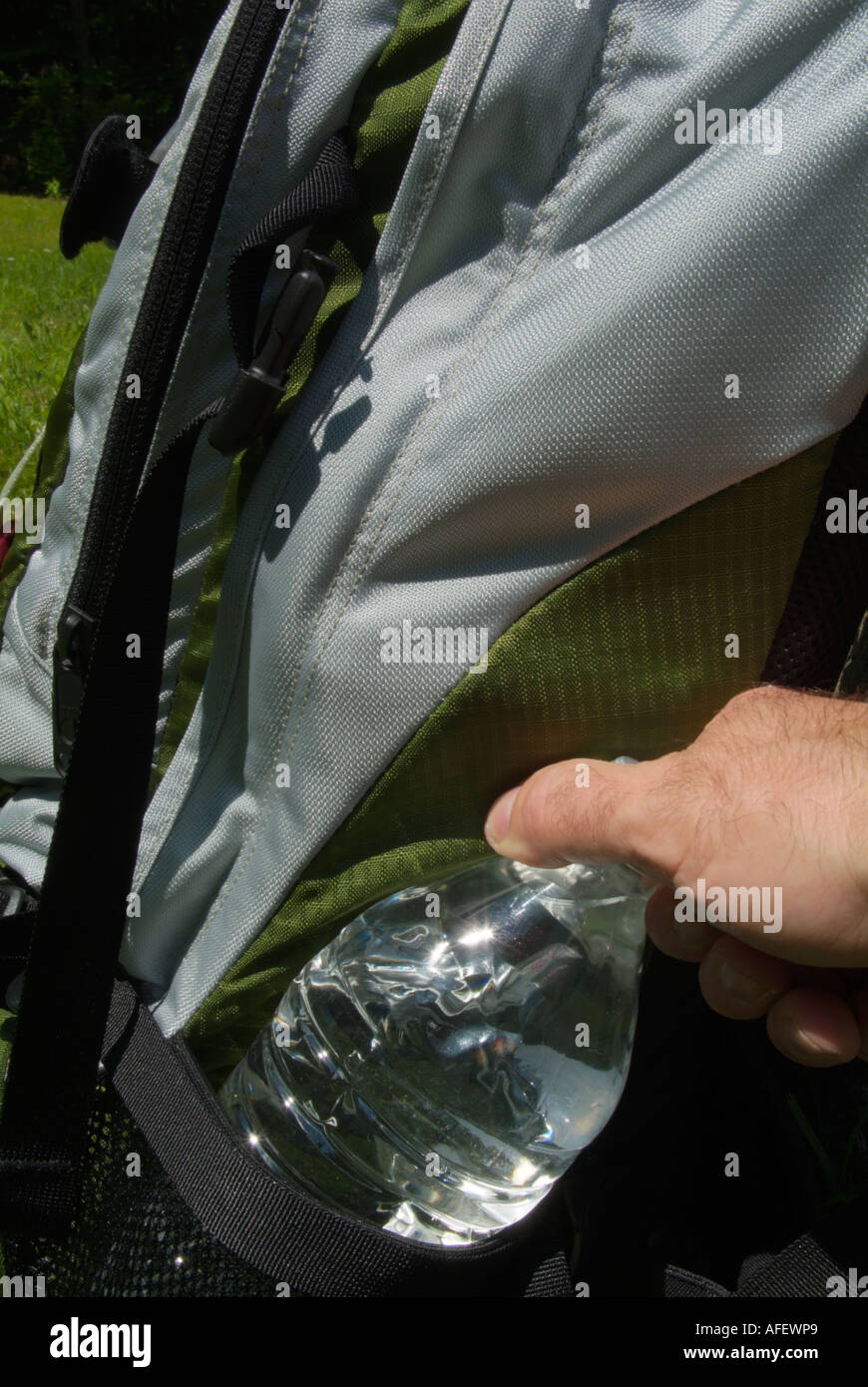 A person's hand taking water bottle out the holder on the side of a ...