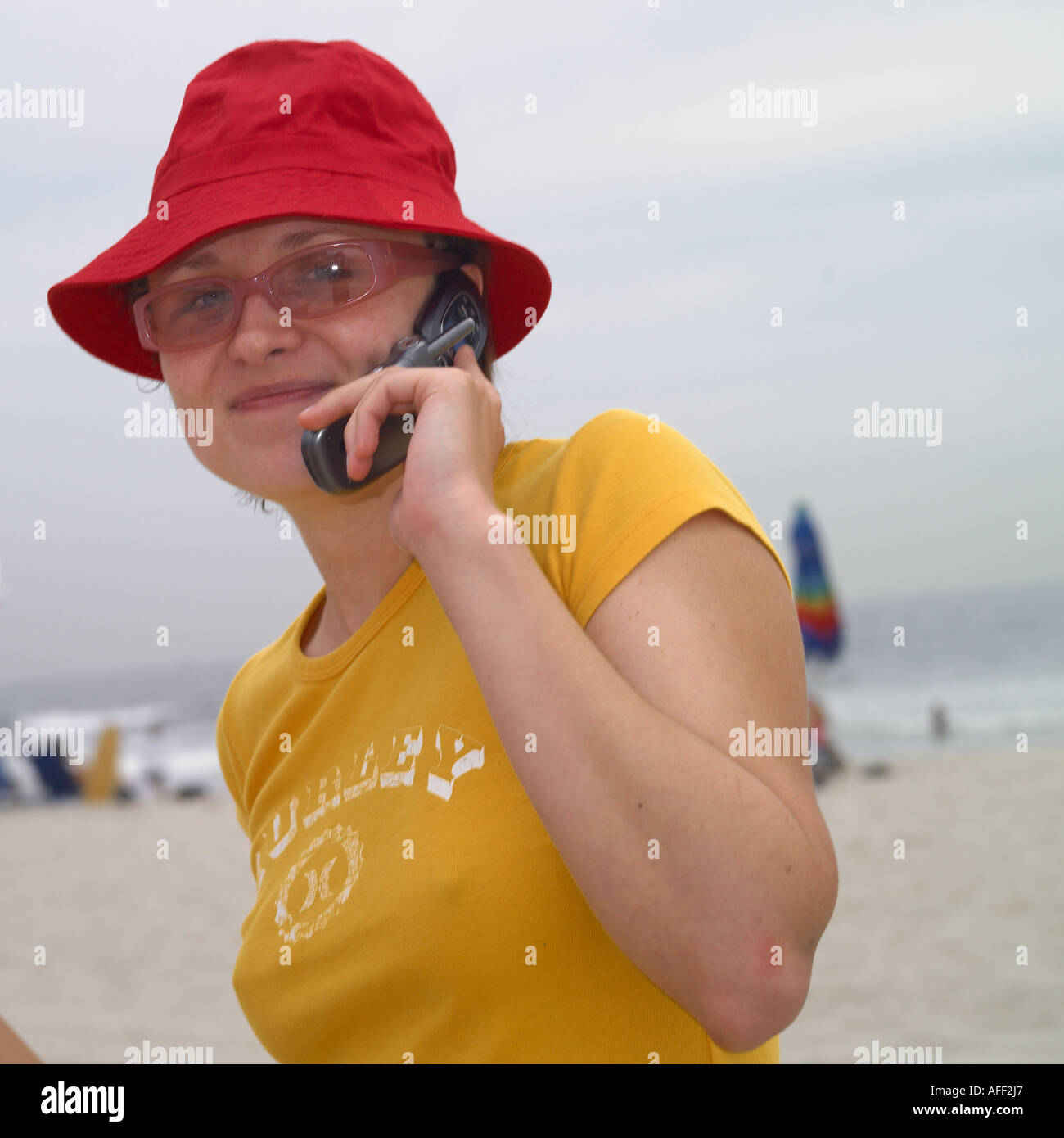 young woman with a cell phone on the beach Stock Photo - Alamy