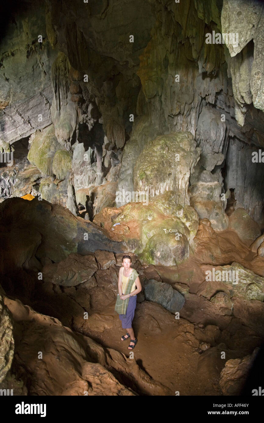 Woman tourist explores the large gallery in the Tham Phu Kham (Poukham ...