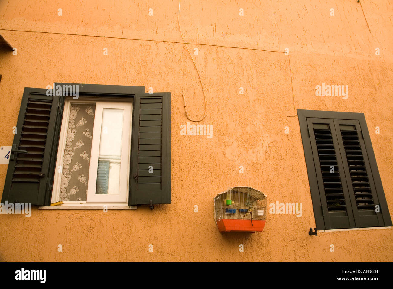 Birdcage on facade of house in Porto Santo Stefano Monte Argentario ...