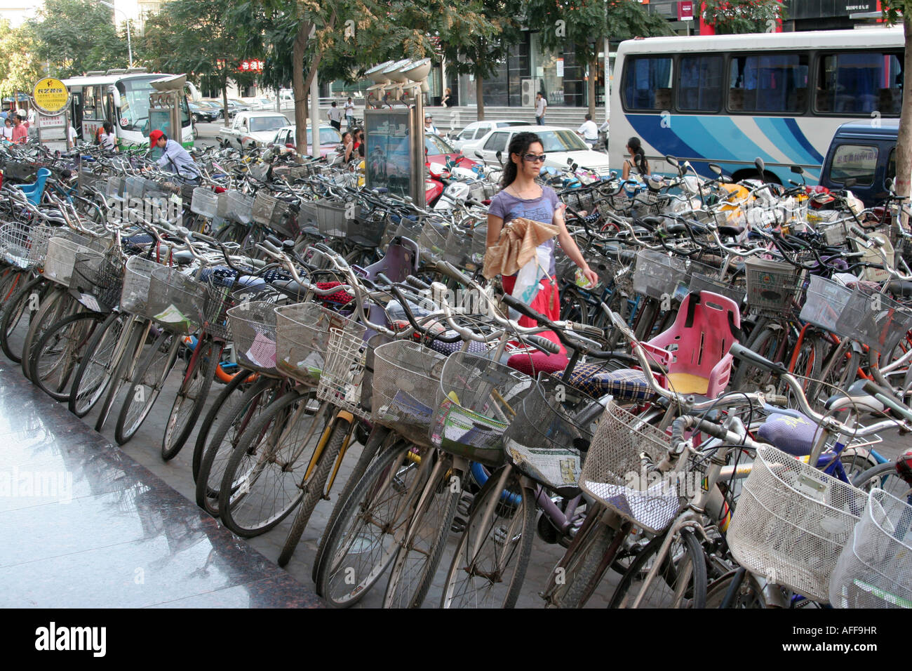 young chinese girl walking among bicycles Yinchuan town Ningxia China ...
