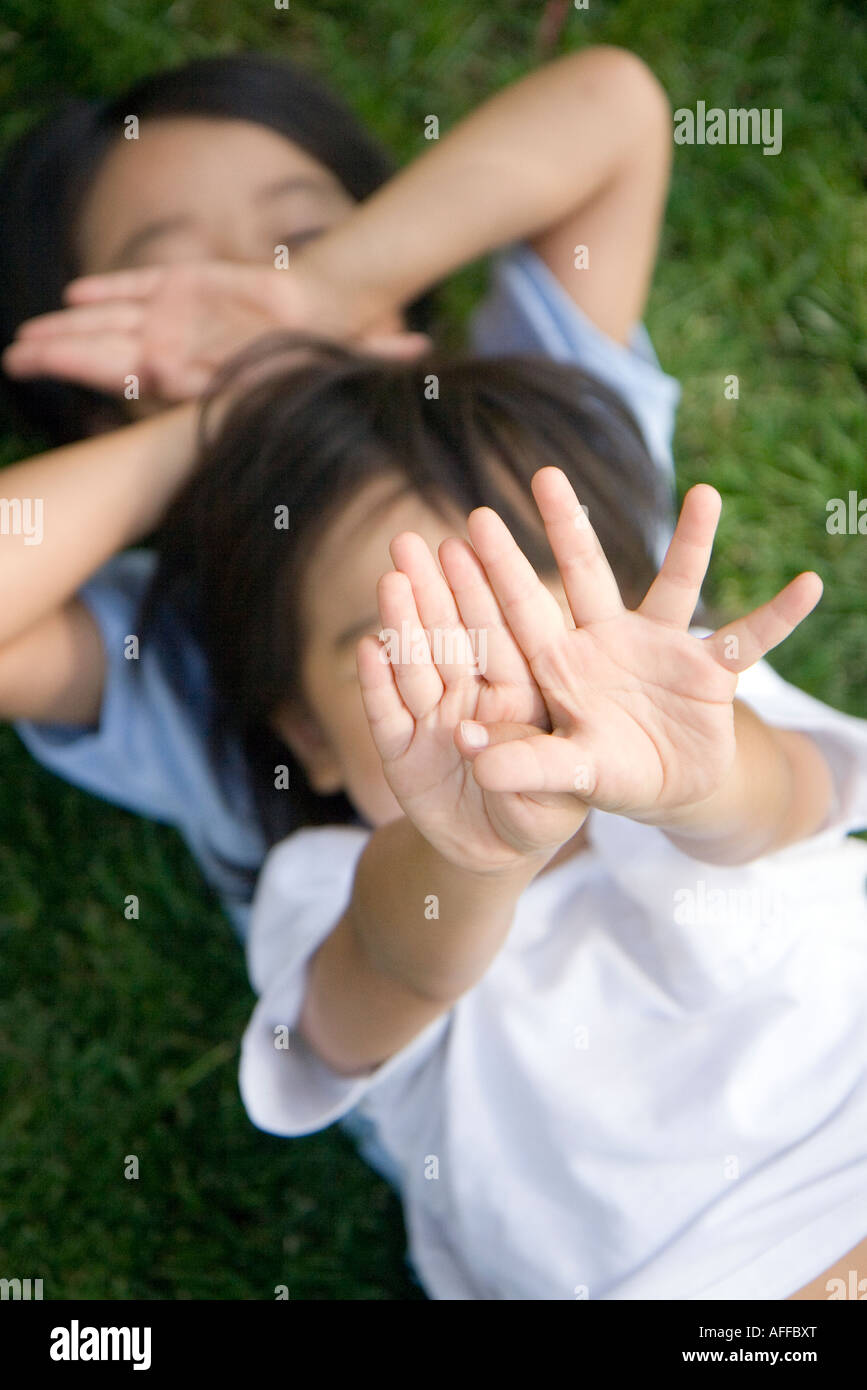 Young Boys with Hands over Faces Stock Photo - Alamy
