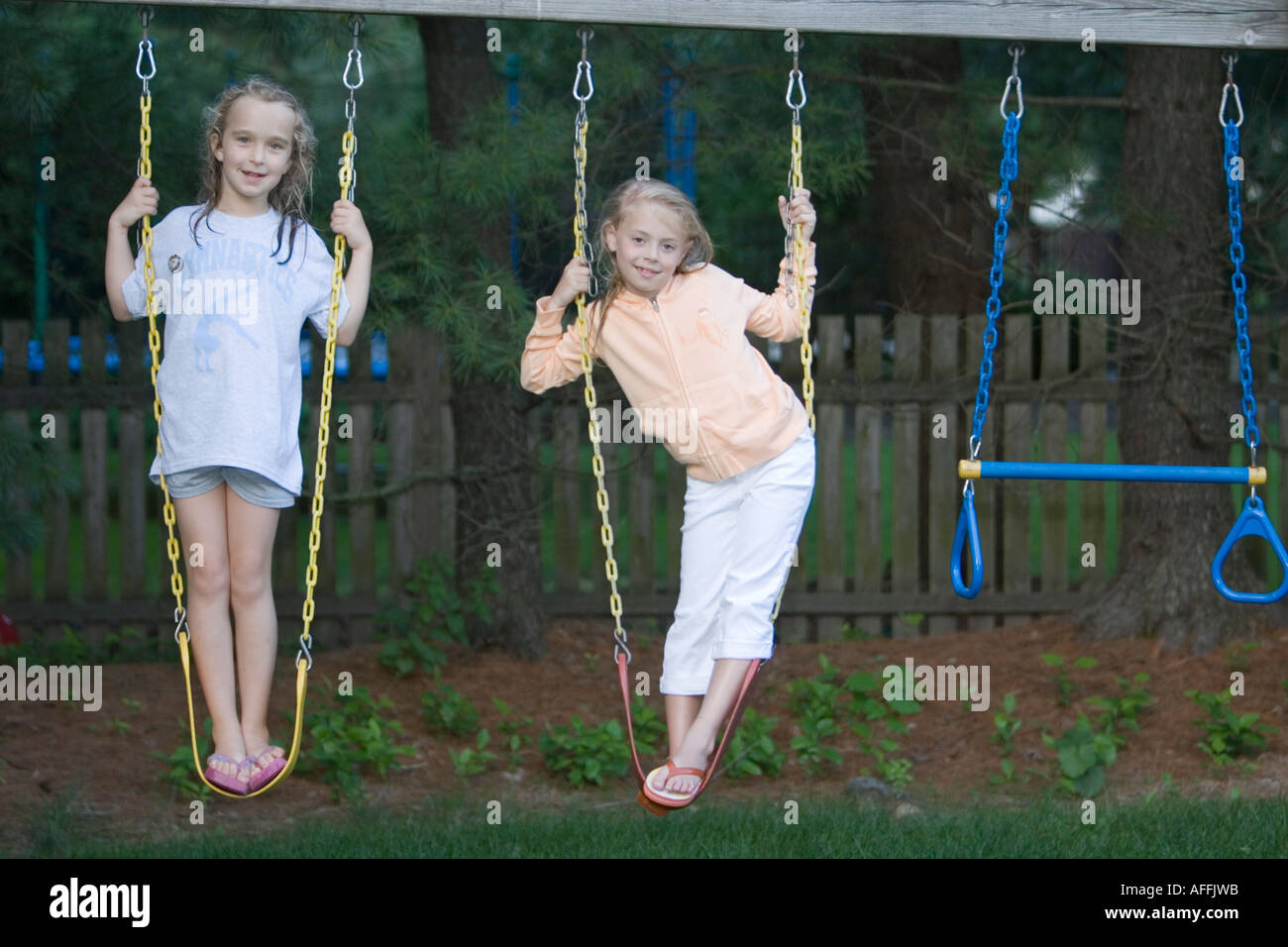 Children taking a rest from swinging in the backyard Stock Photo - Alamy