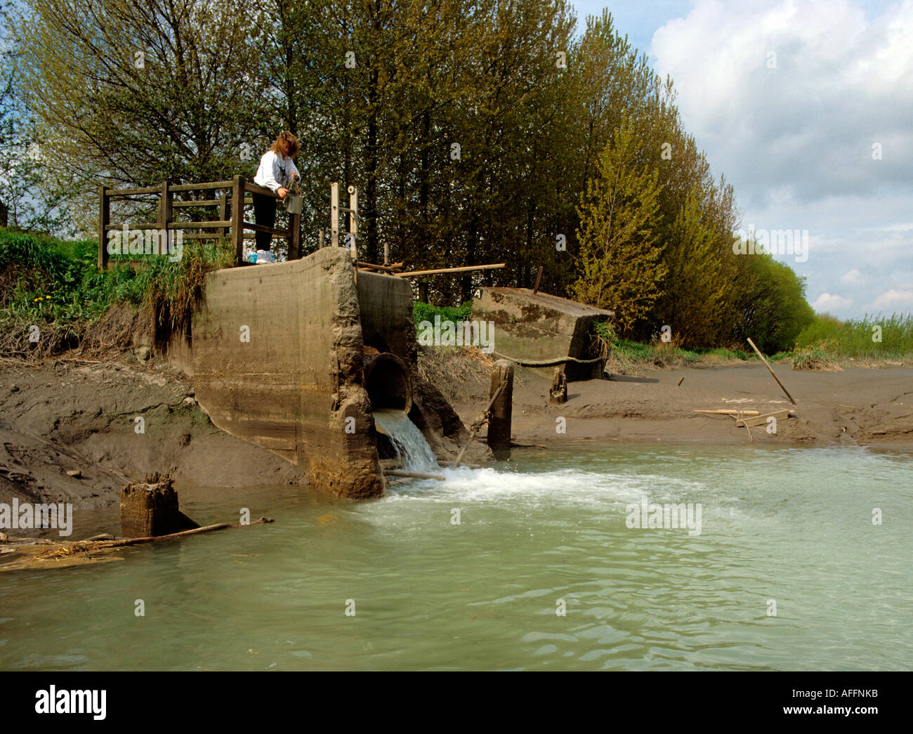 Water Environment Agency officer sampling water from factory outfall ...