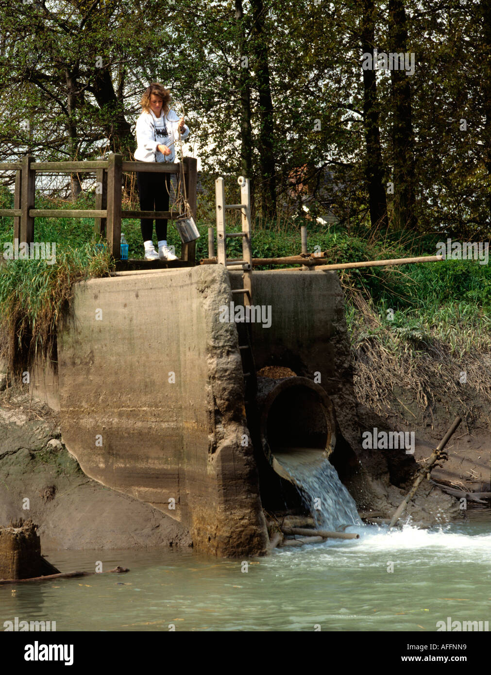 Water Environment Agency officer sampling water from factory outfall ...