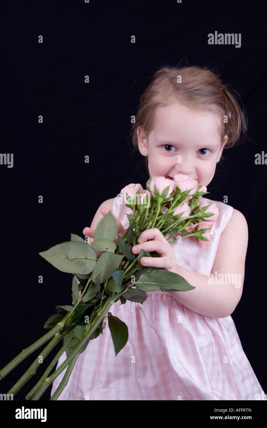 Little girl smelling roses Stock Photo - Alamy