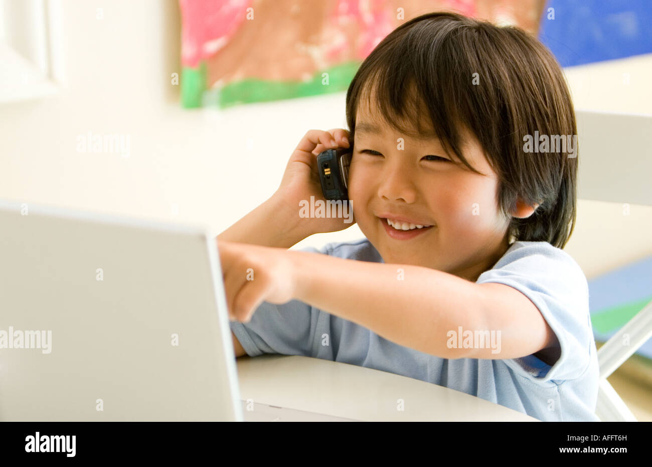 Young Boy on Phone and Pointing to Laptop Screen Stock Photo - Alamy