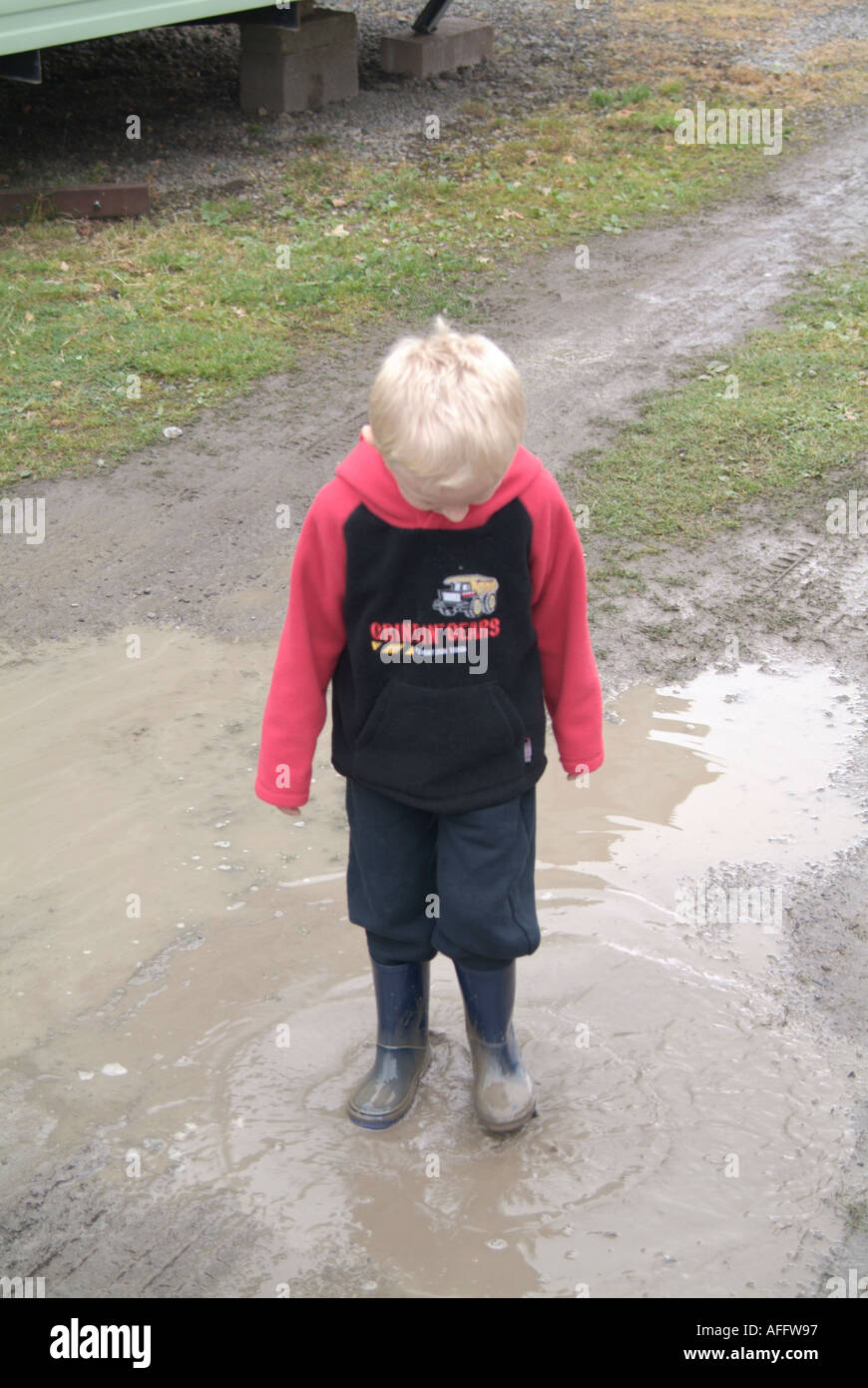 small boy playing in a puddle Stock Photo - Alamy