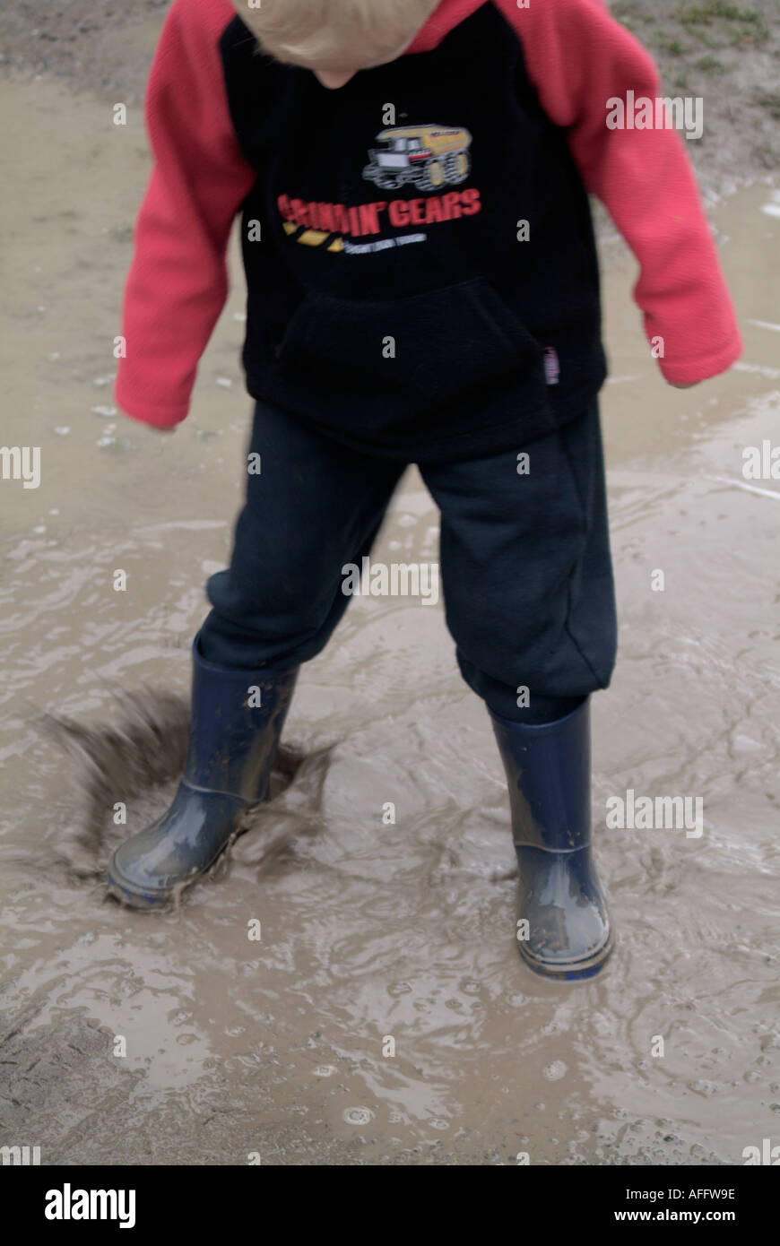 small boy playing in a puddle Stock Photo - Alamy