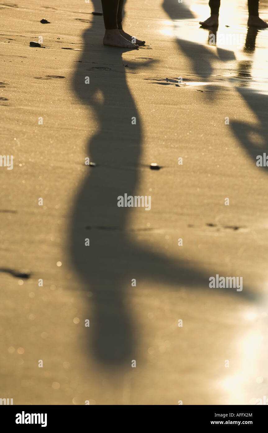 Shadow on beach of triathlete stretching prior to ocean swim, Santa ...