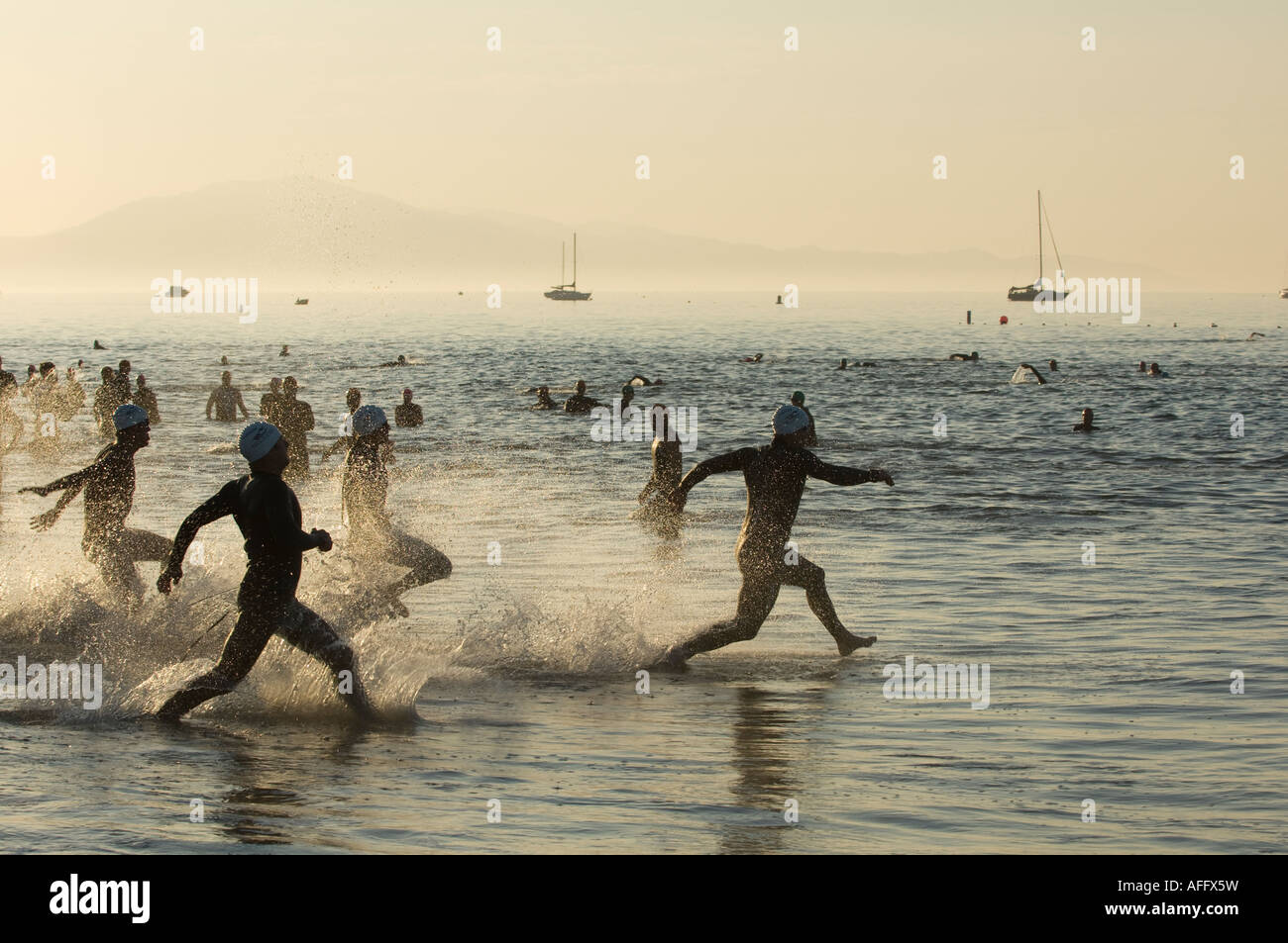 Swimmers run into cold Pacific ocean for swimming section of Santa ...